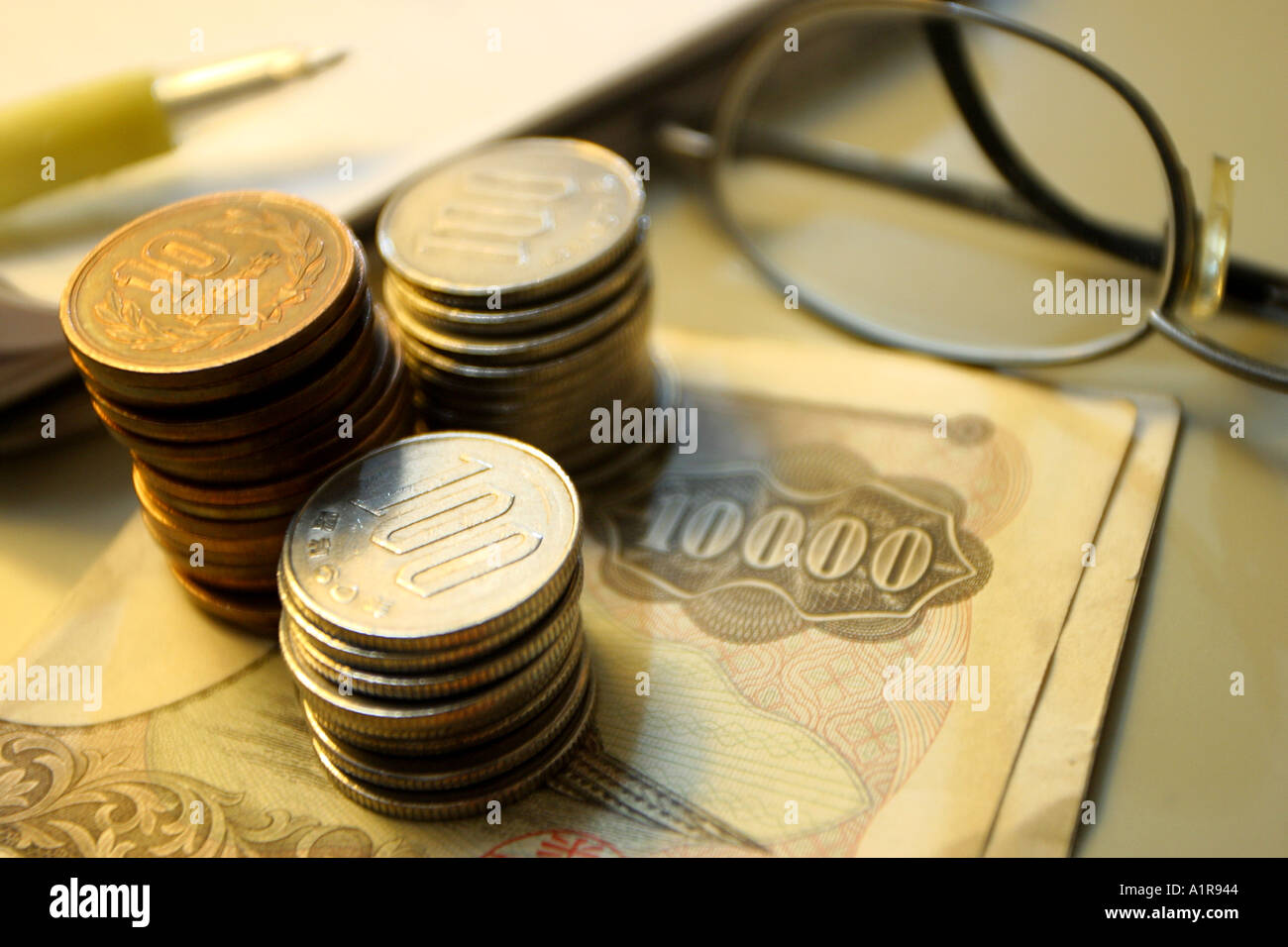 Japanese coins on dollar notes blurred Stock Photo - Alamy