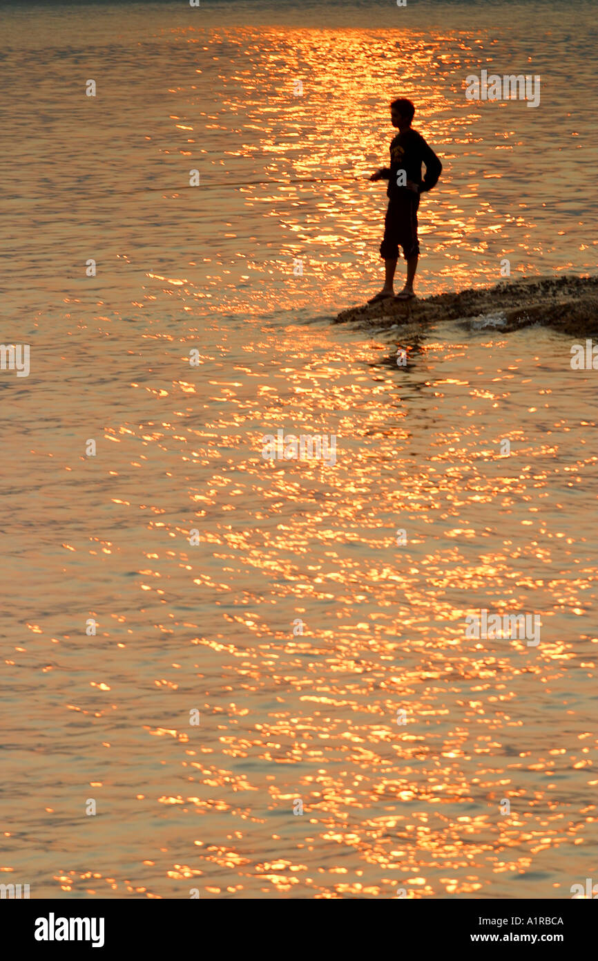 Sunset in beach seaside stone mountain sun reflect inverted image ...