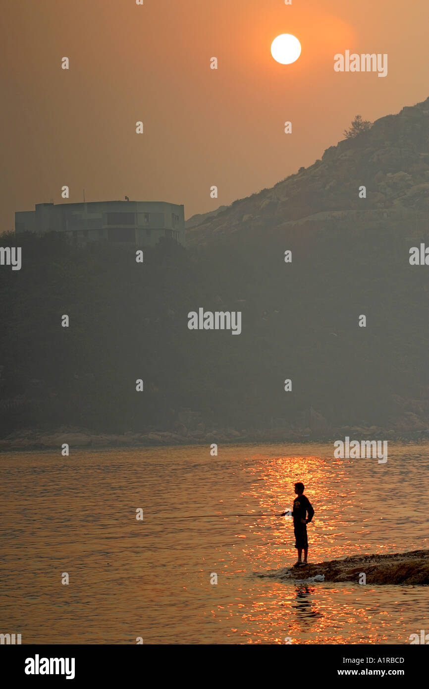 Sunset in beach seaside stone mountain sun reflect inverted image ...