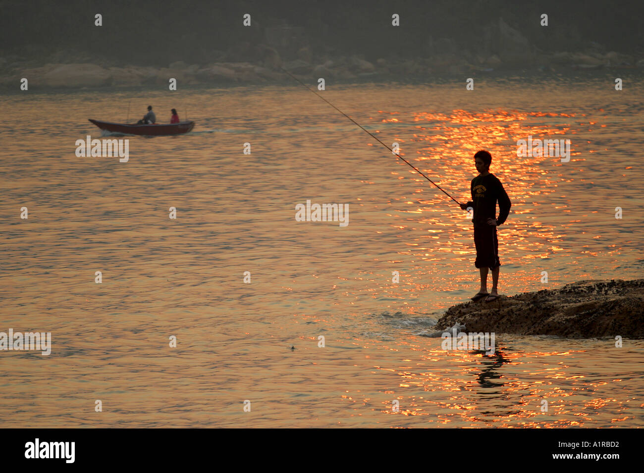 Sunset in beach seaside stone mountain sun reflect inverted image ...