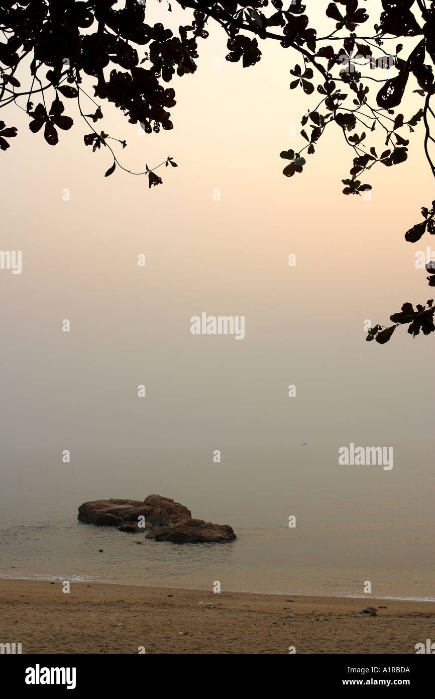 Sunset in beach seaside stone mountain sun reflect inverted image ...