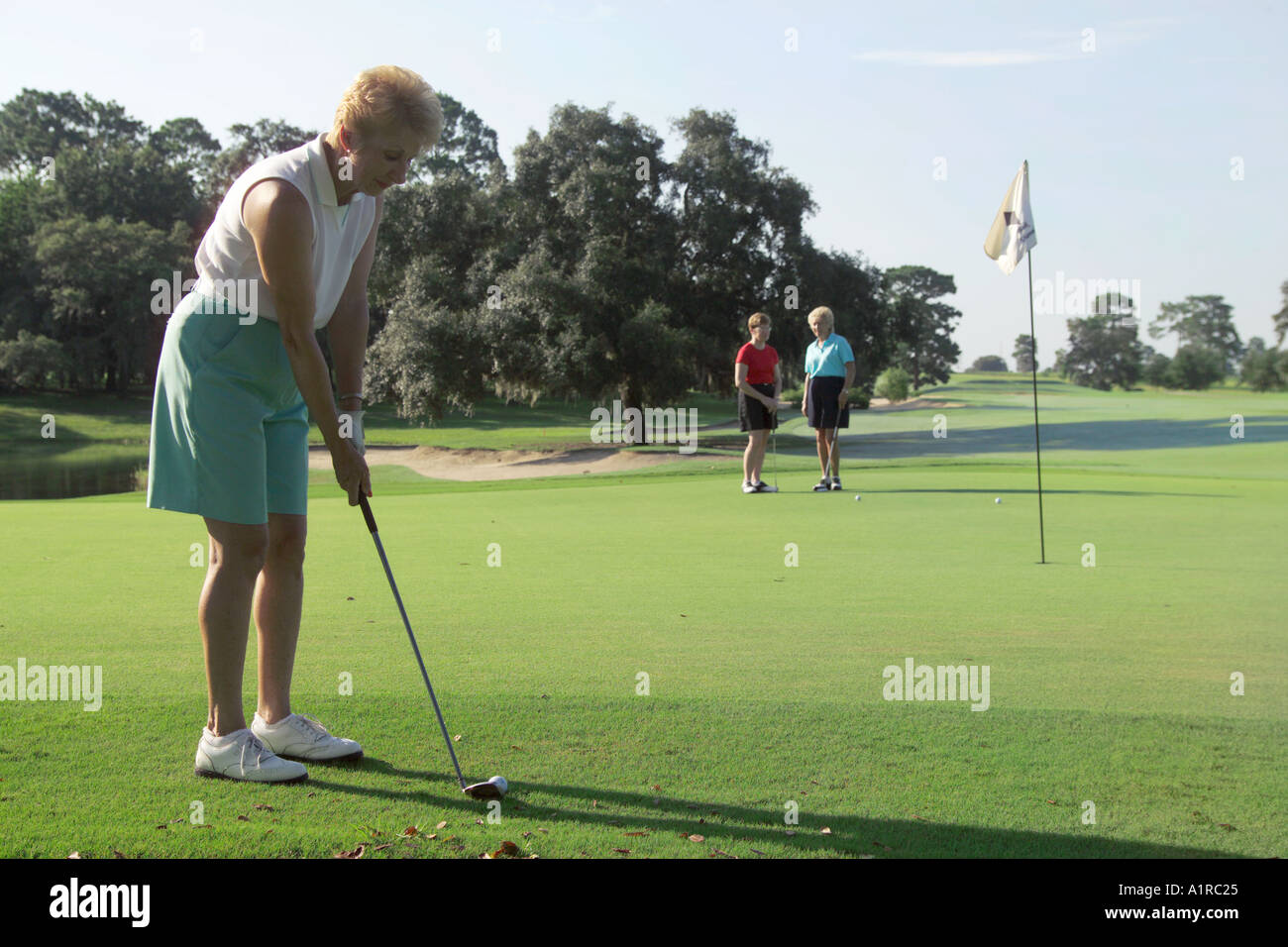 Senior women golfers chips onto green Stock Photo - Alamy