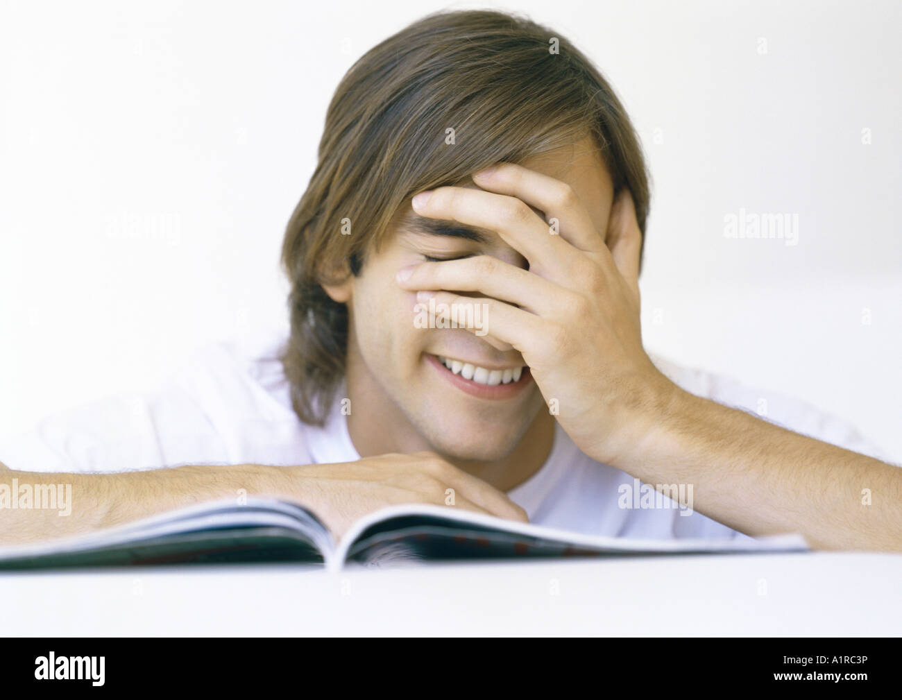 Man with book, covering face Stock Photo - Alamy