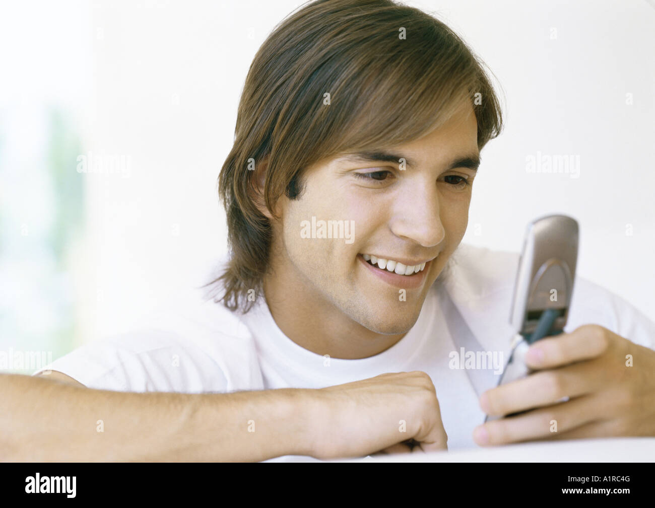 Man looking at cell phone, smiling Stock Photo - Alamy