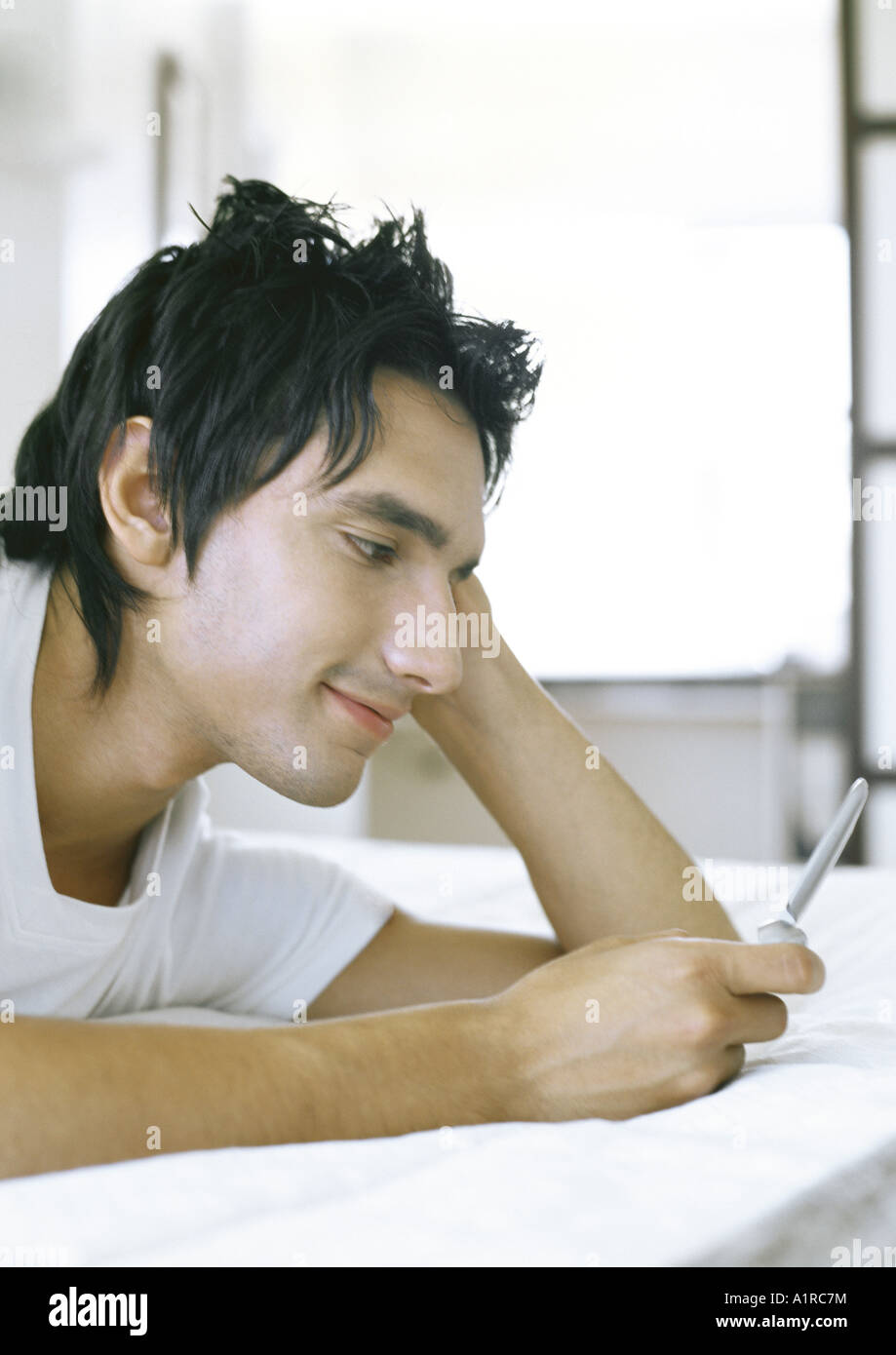 Man looking at cell phone, smiling Stock Photo - Alamy