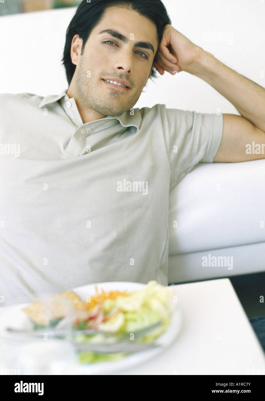 Man sitting at table, with meal, leaning back and looking away Stock ...