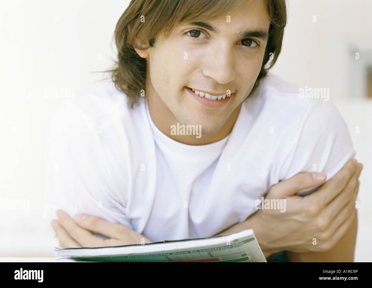 Man with magazine, smiling at camera Stock Photo - Alamy