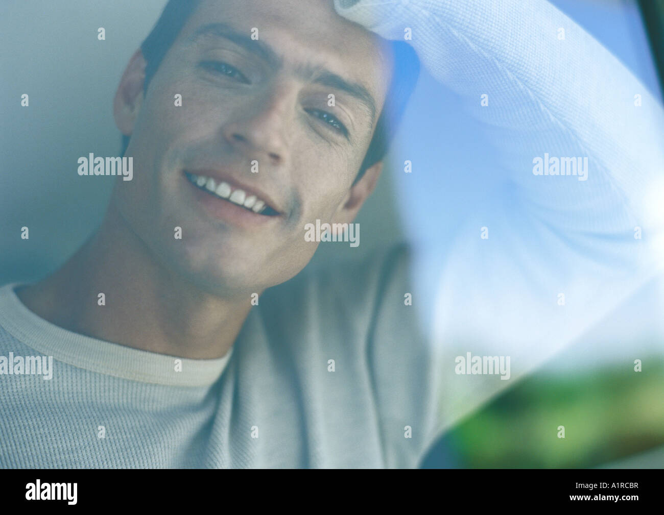 Man smiling, seen through window Stock Photo - Alamy