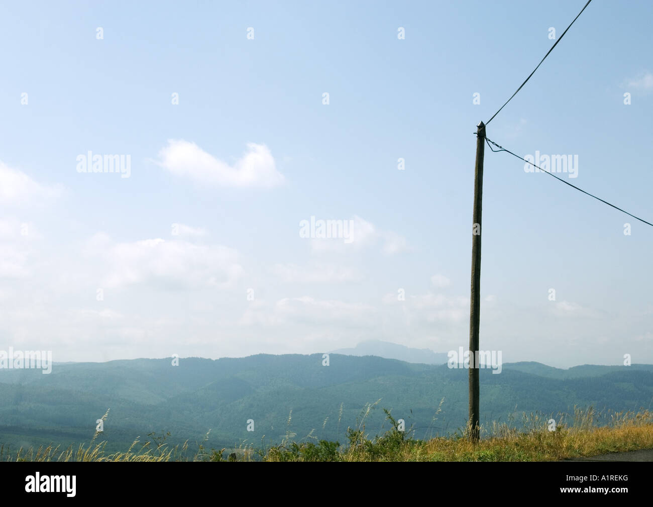 Electric post, mountainous landscape in background Stock Photo - Alamy