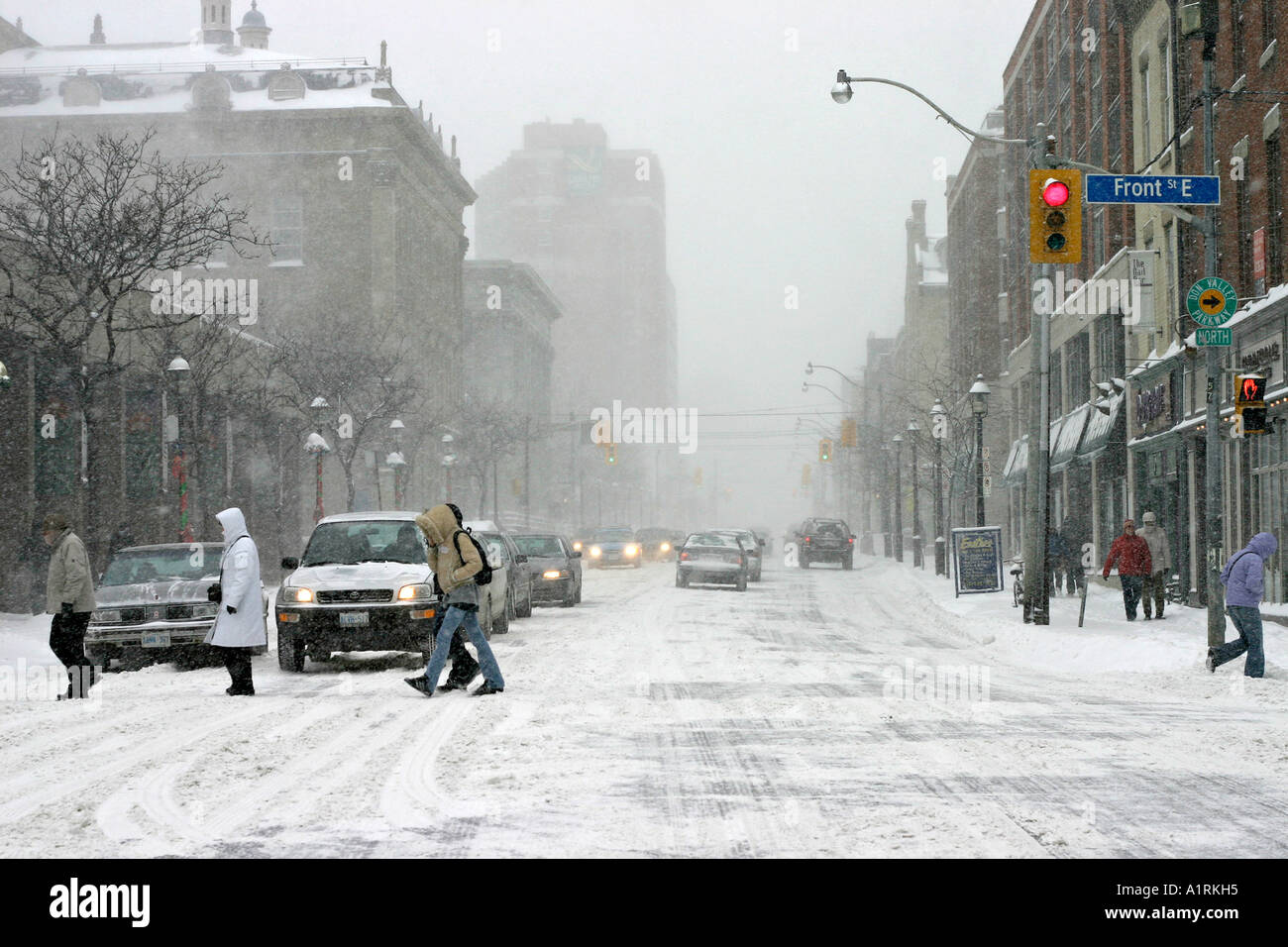 Pedestrians and Automobiles mix on a snow covered city street Toronto ...
