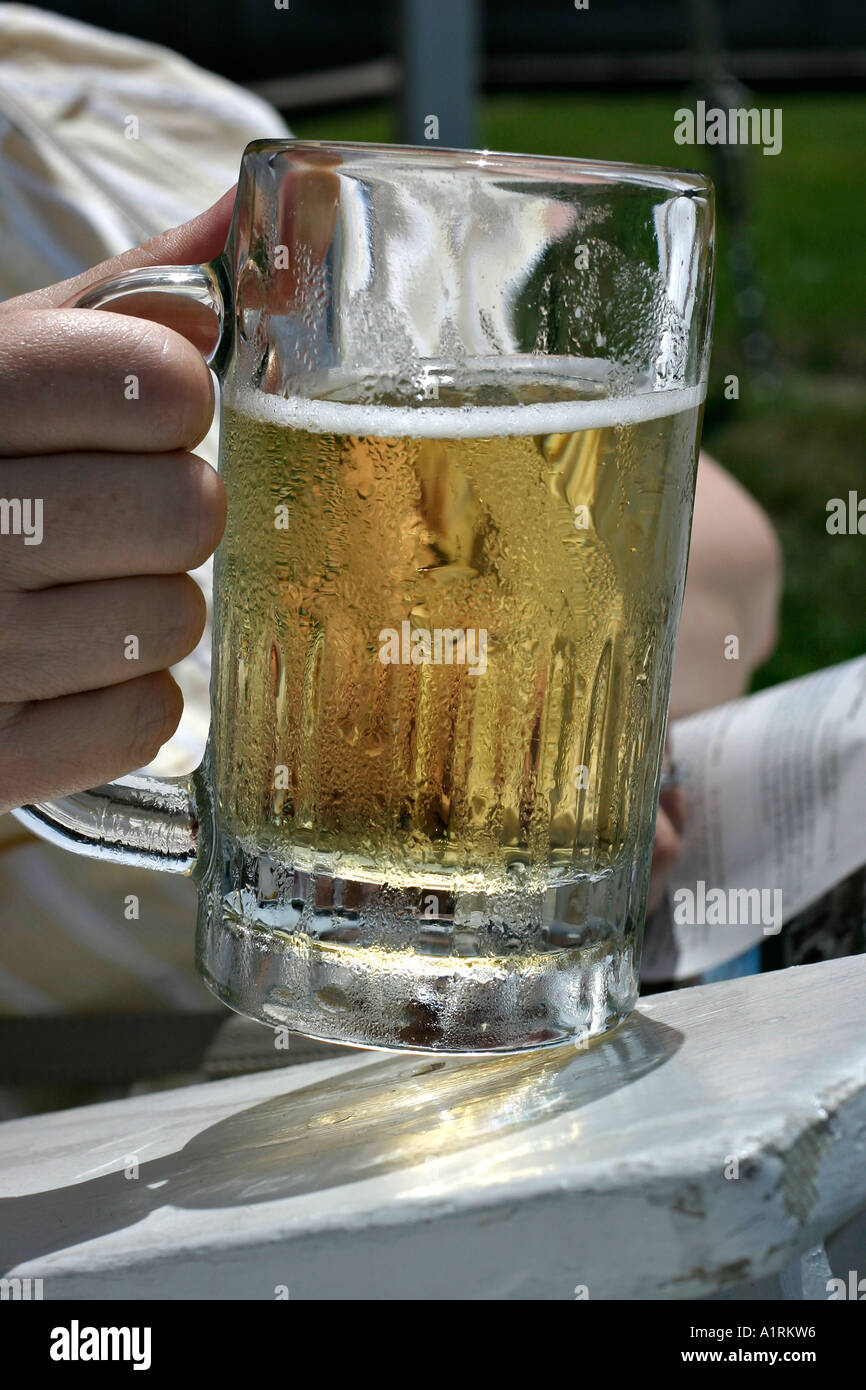 Half Empty: A half empty mug of beer being lifted by a woman s hand ...