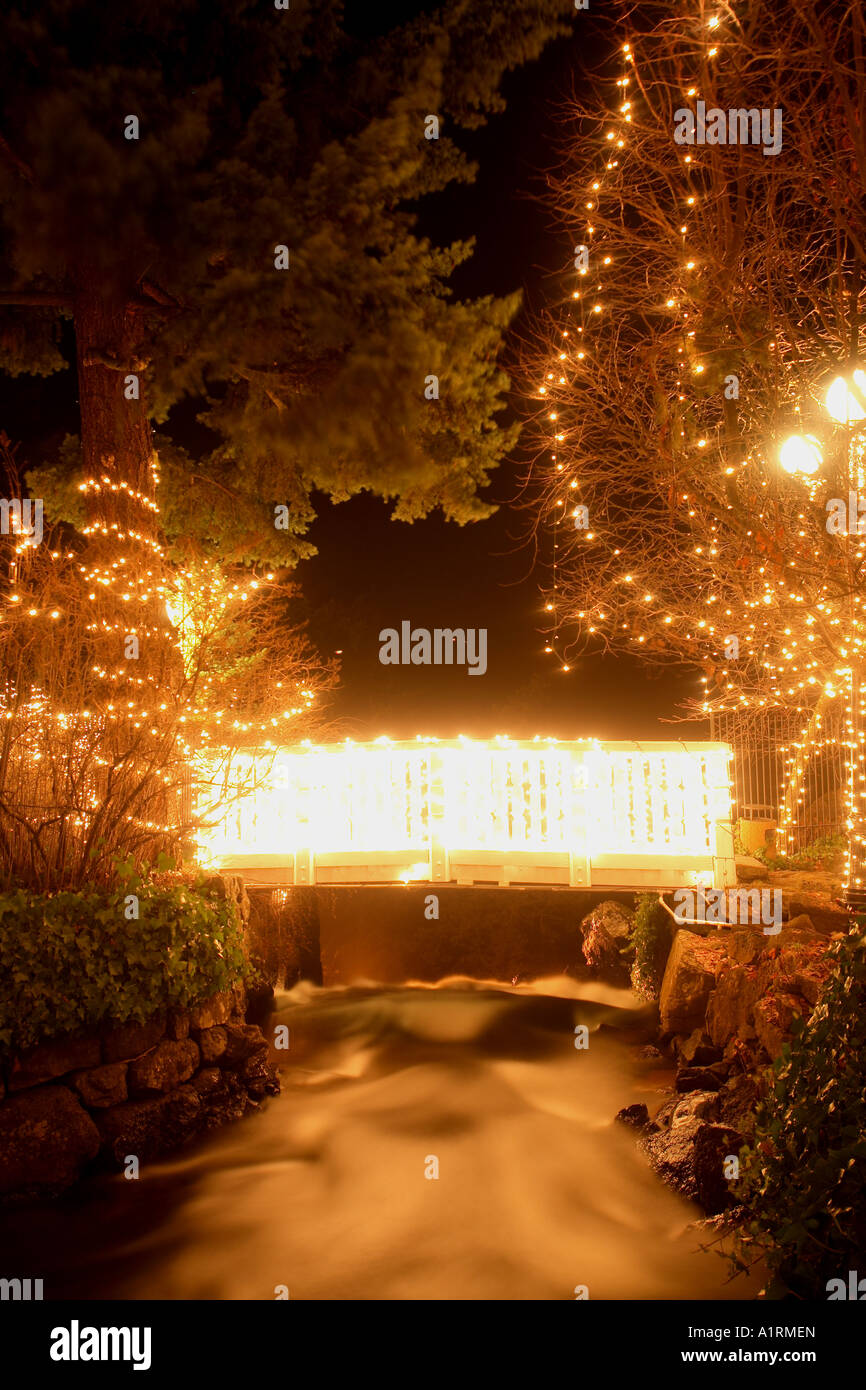 A white bridge over a stream lit with christmas lights at nigth Stock ...