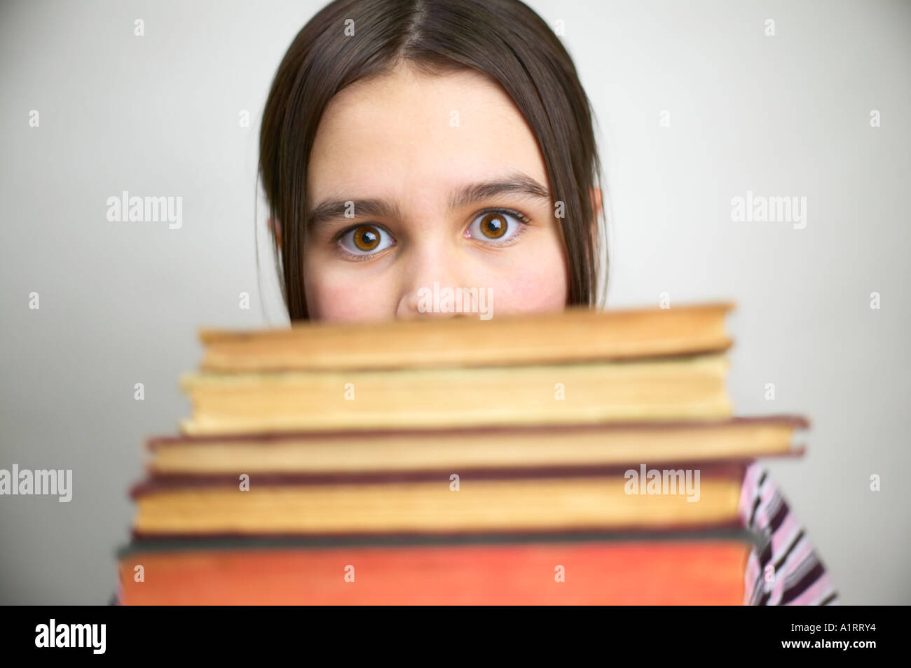 Young girl carrying stack of books Stock Photo - Alamy
