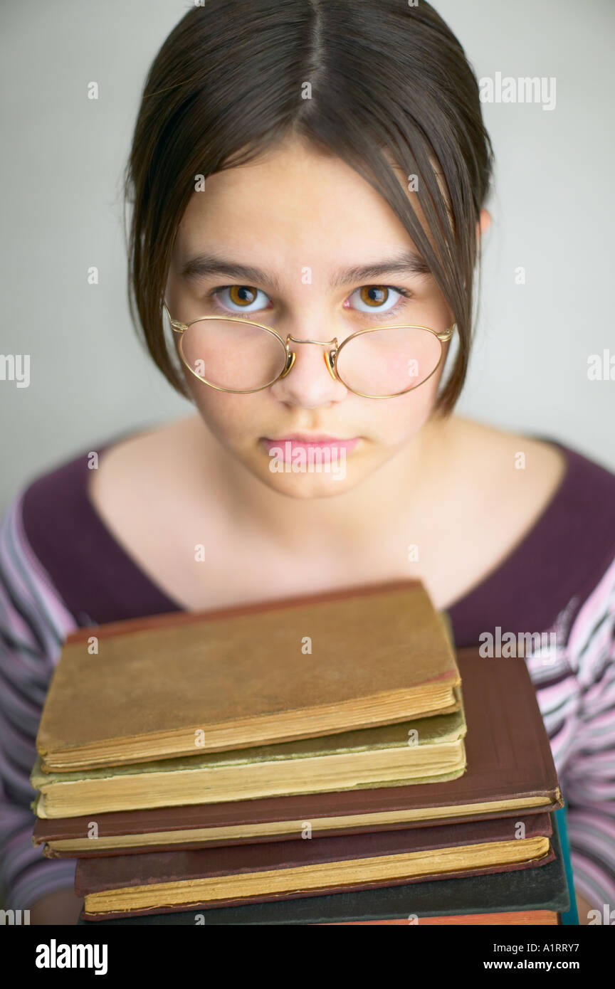 Young girl carrying stack of books Stock Photo - Alamy