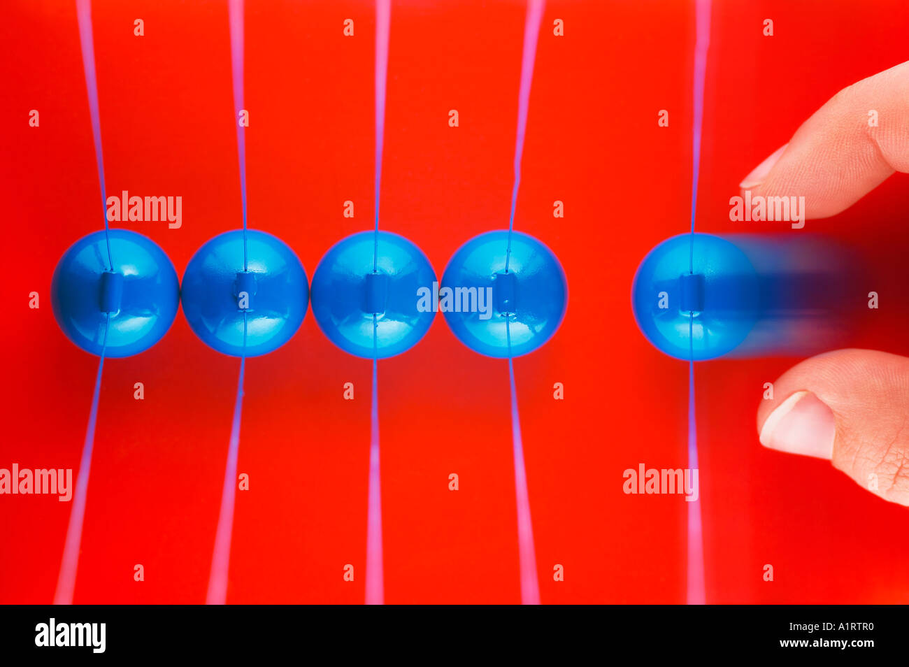 Finger and thumb releasing ball on Newton s cradle device Stock Photo ...