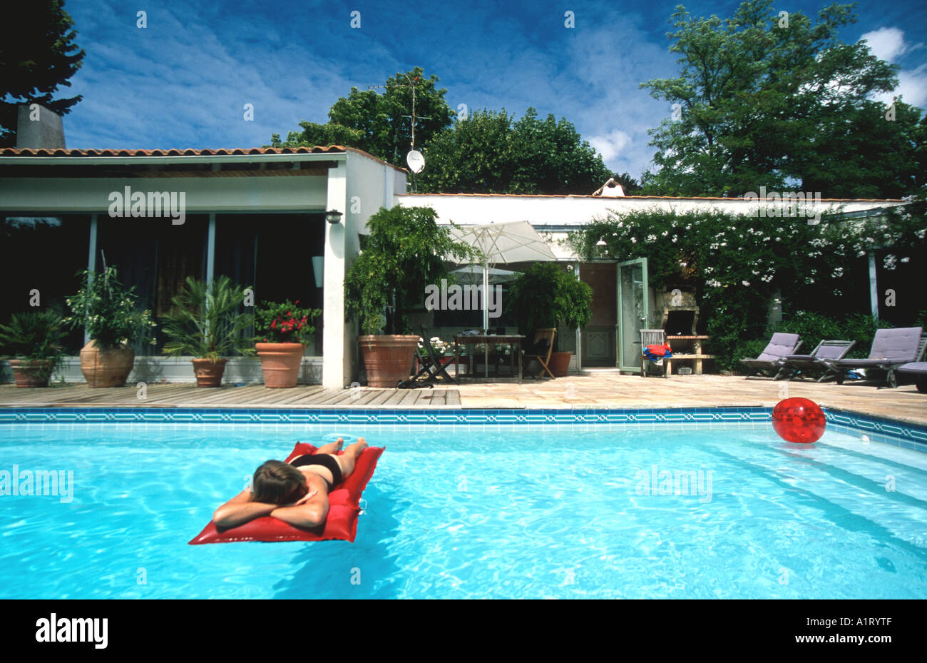 Woman 30 40 yrs floating on inflatable airbed lilo in swimming pool ...