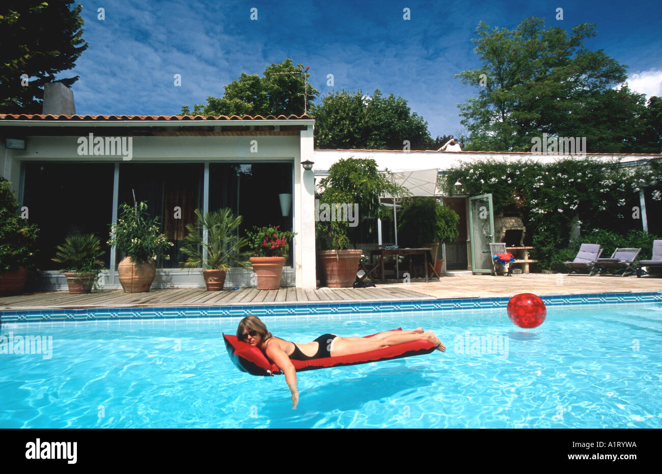 Woman 30 40 yrs floating on inflatable airbed lilo in swimming pool ...