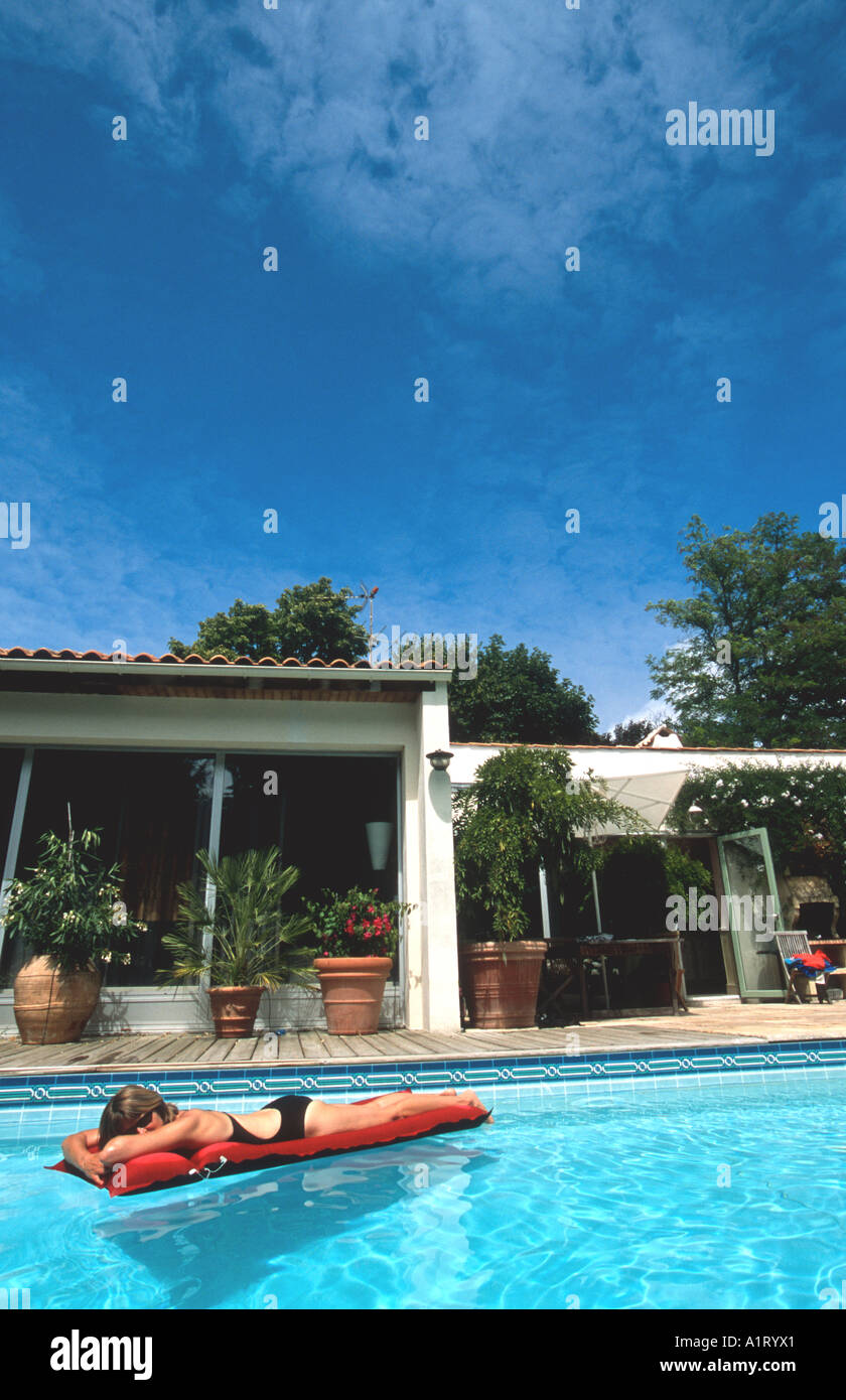 Woman 30 40 yrs floating on inflatable airbed lilo in swimming pool ...