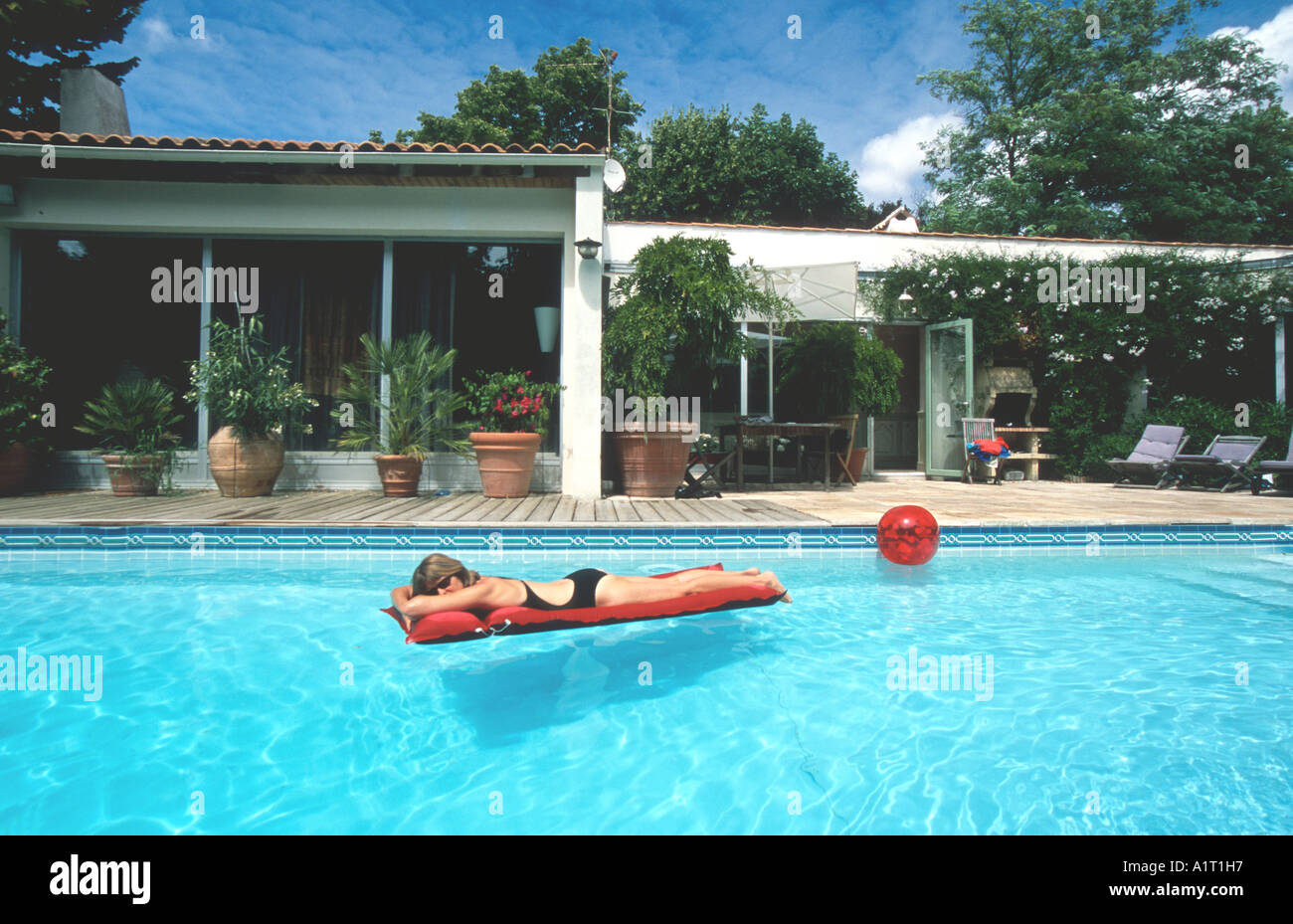 Woman 30 40 yrs floating on inflatable airbed lilo in swimming pool ...