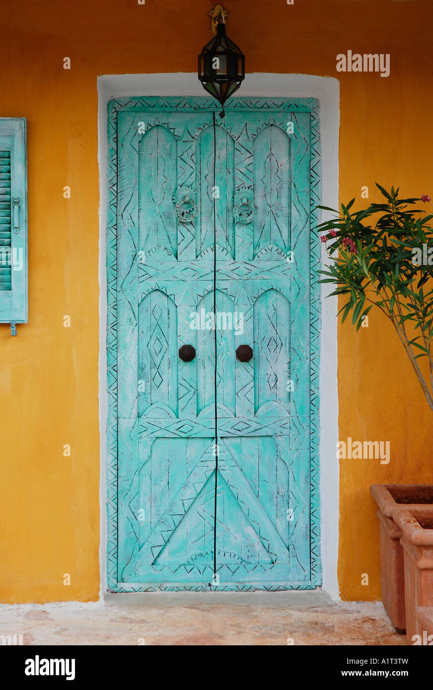old light blue Mediterranean detailed door against yellow painted wall ...