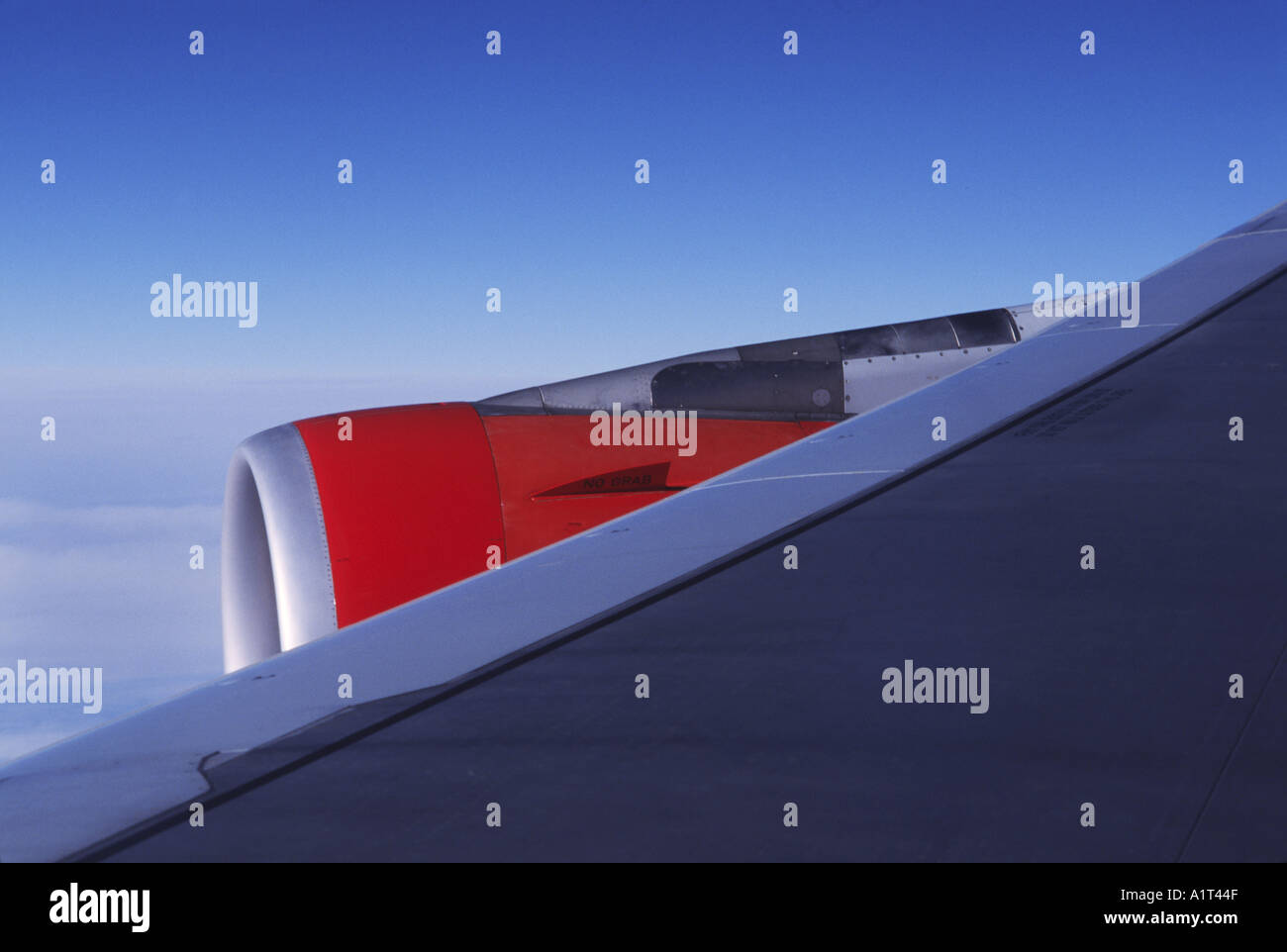 Red aircraft engine and section of wing on an Airbus passenger plane ...