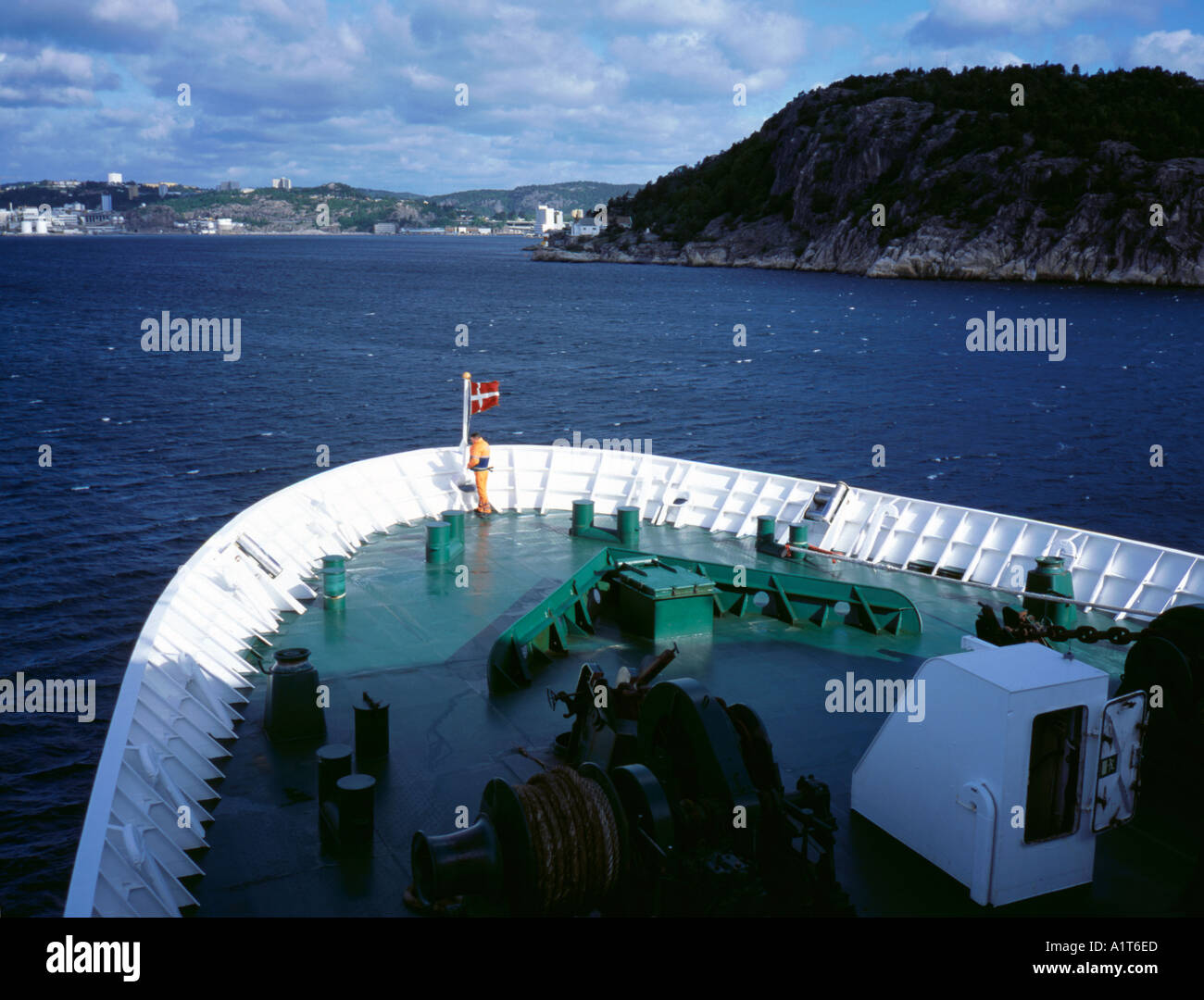 Man hoisting Danish flag on a ferry as it enters Kristiansand, Vest ...