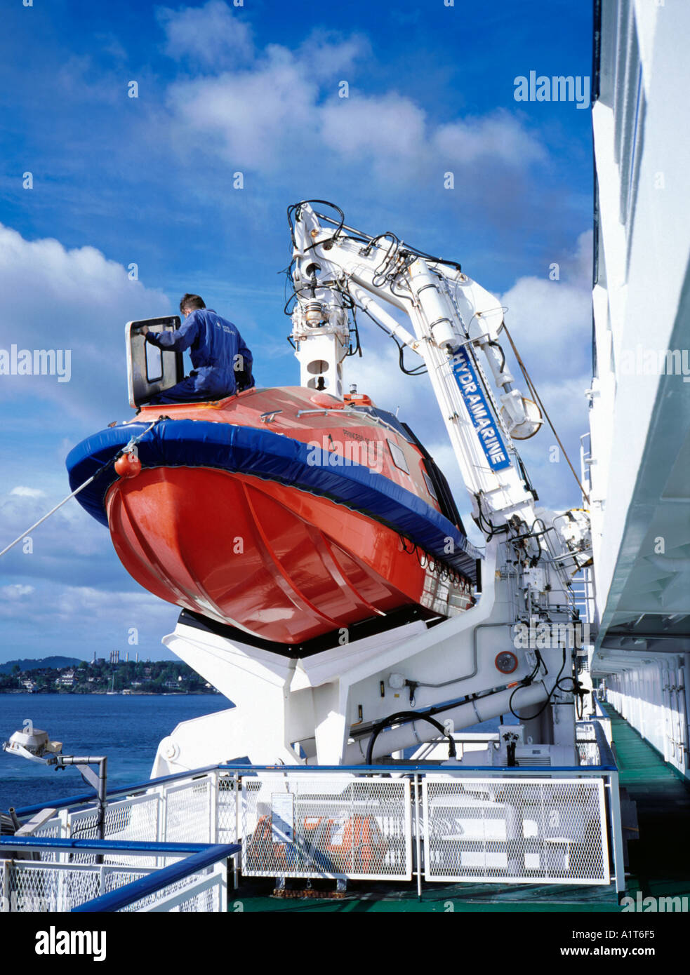Crew checking a modern fibreglass lifeboat on a hydraulic davit, on a ...