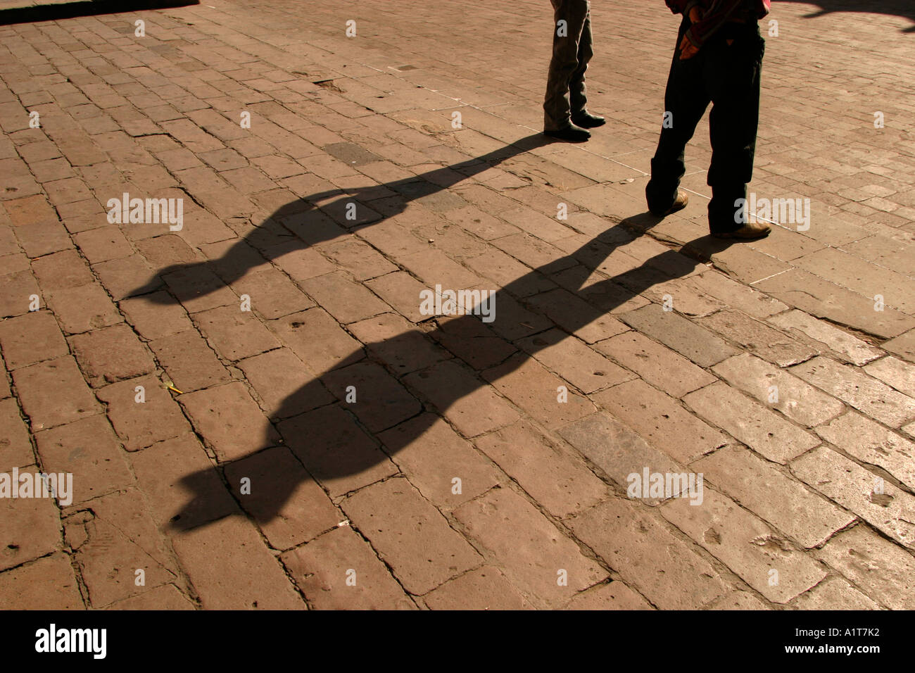 early morning shadow of two men in a mexican city square Stock Photo ...