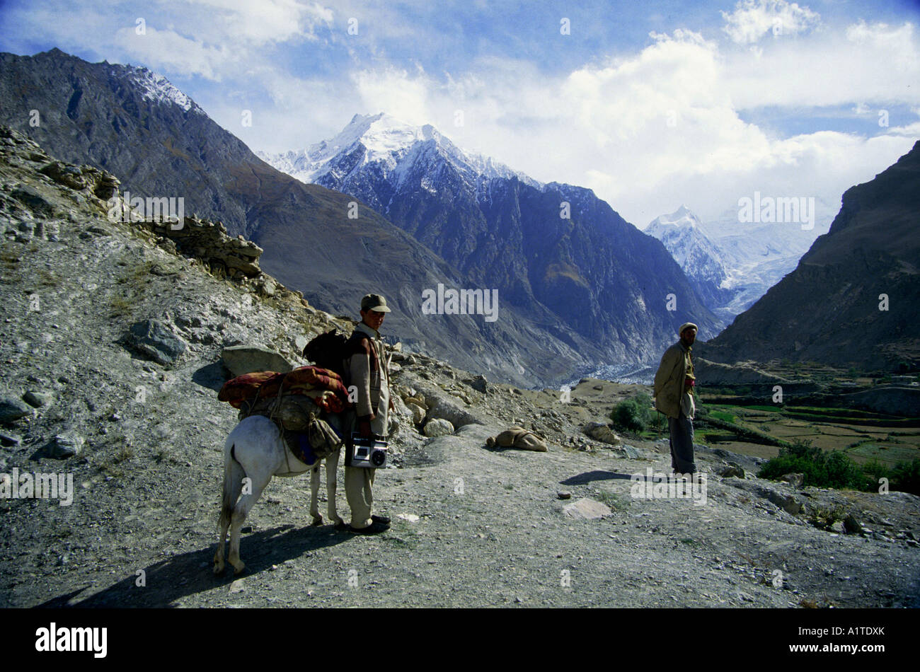 young man with radio receiver on mule track view from nagar valley to ...