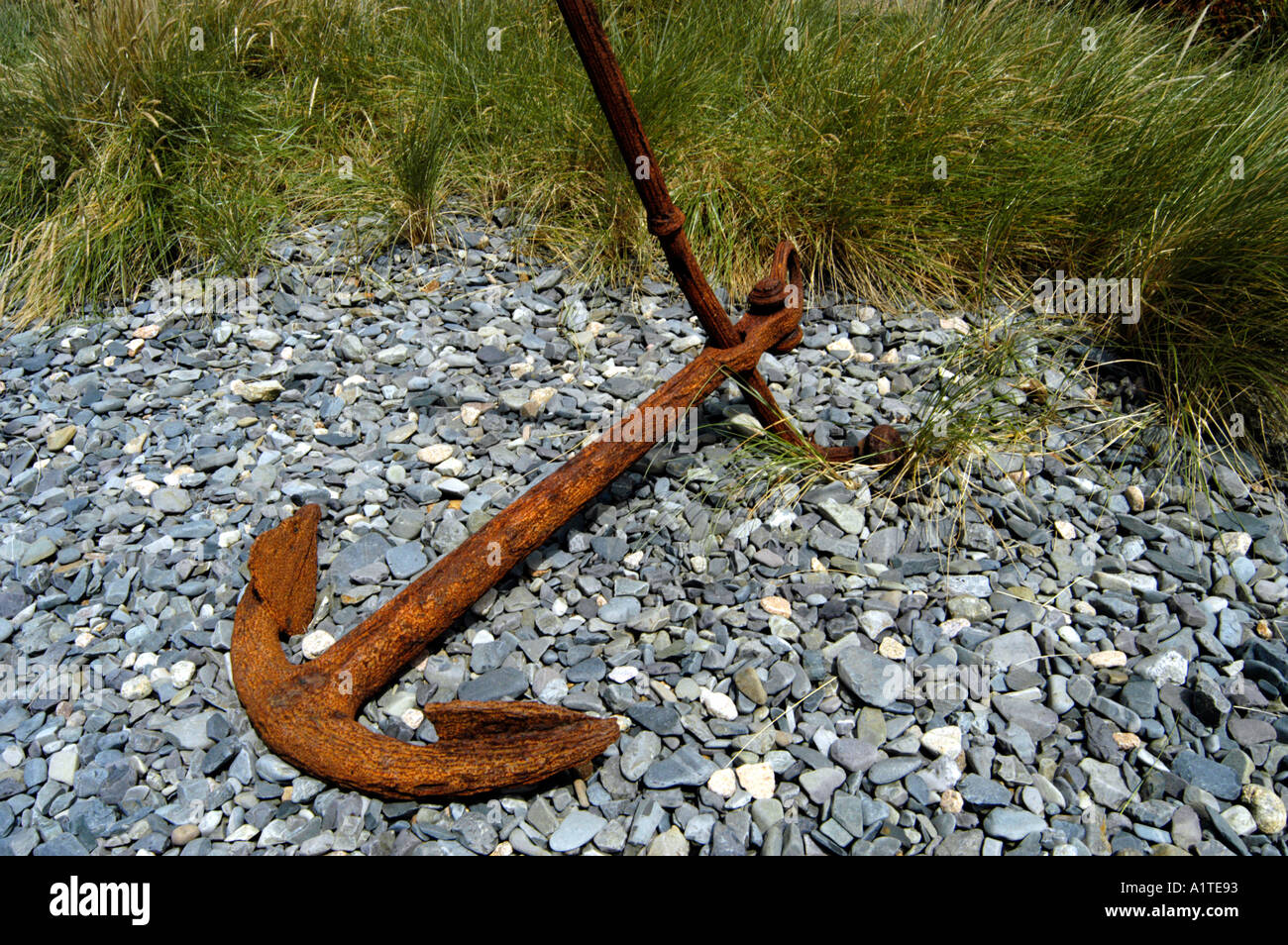 Rusty anchor abandoned on a pebble beach Stock Photo - Alamy