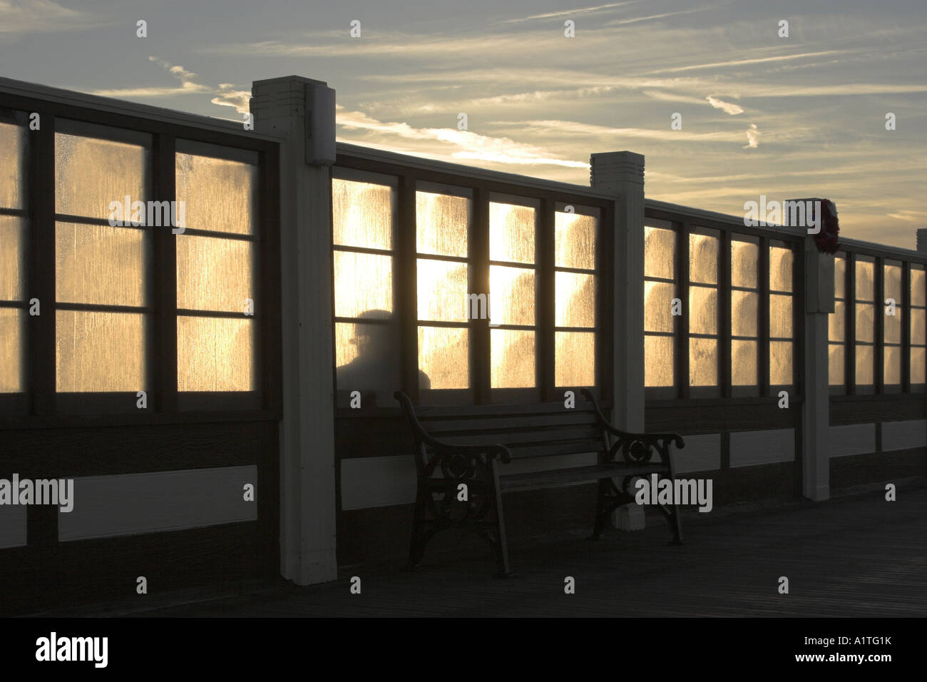 Early morning sun casts shadows and a silhouette on empty benches ...