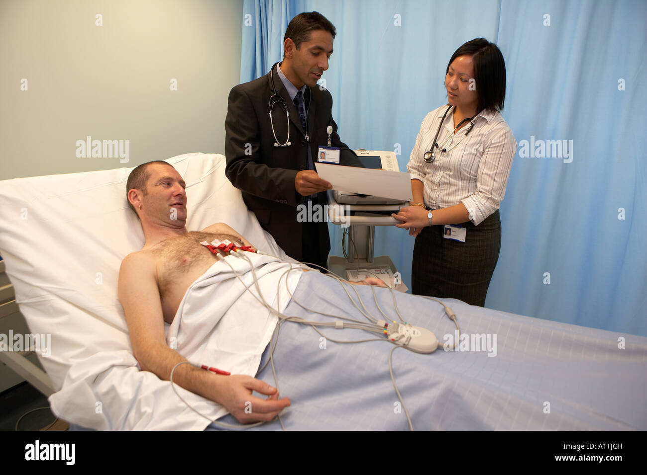 Male doctor showing junior doctor the ECG results from a male parient ...