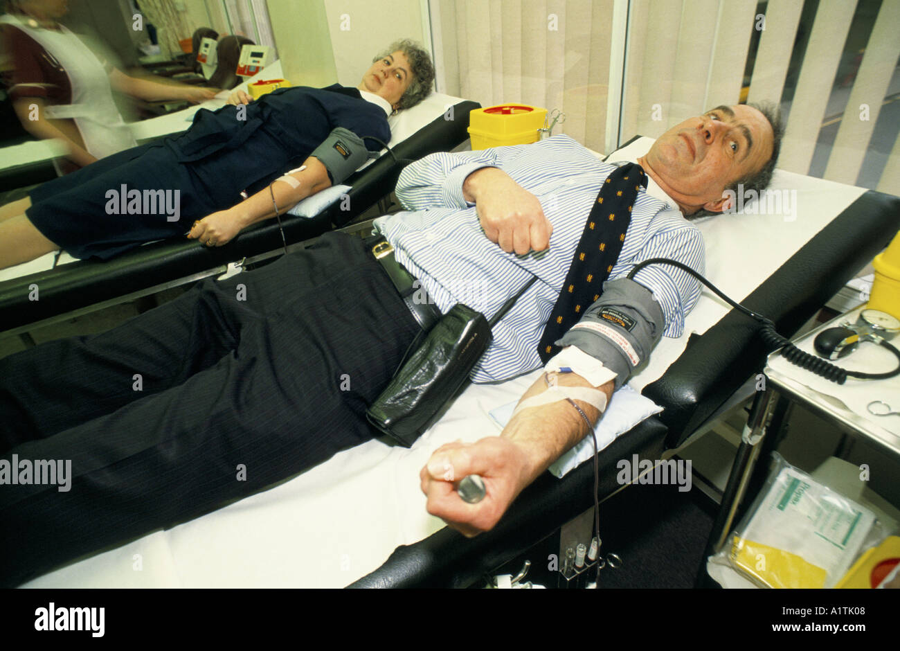 BLOOD DONATION CENTER A WOMAN AND A MAN DONORS LYING ON A BLACK BED ...