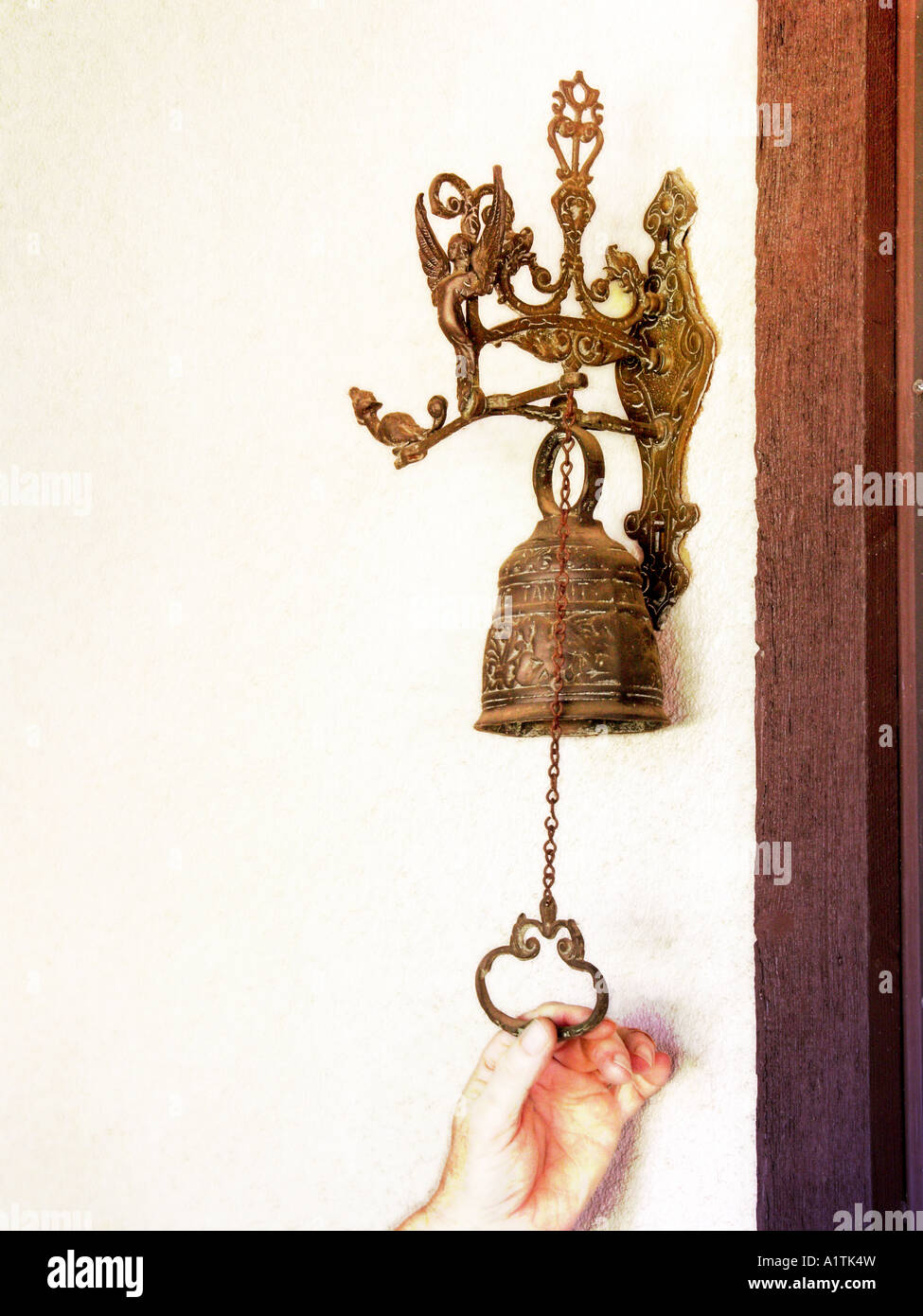 Hand ringing an ornamental door bell Stock Photo - Alamy