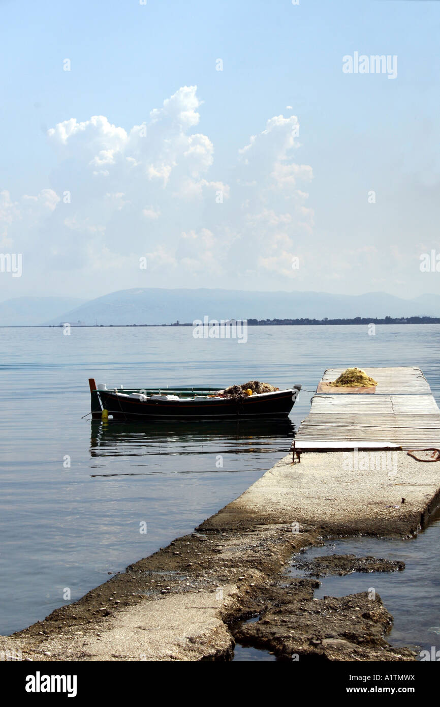 A SMALL ROWING BOAT MOORED TO A JETTY AT PETRETI. CORFU. IONIAN GREEK ...
