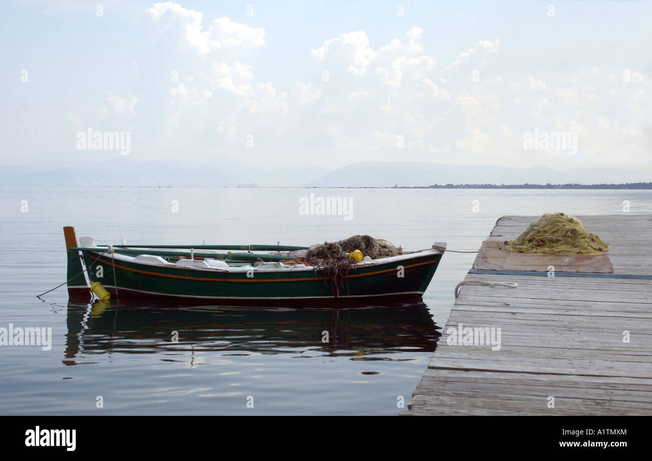A SMALL ROWING BOAT MOORED TO A JETTY AT PETRETI. CORFU. IONIAN GREEK ...