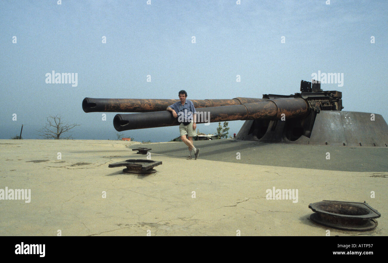 Tourist posing on old French guns on the Isle de Goree near Dakar ...