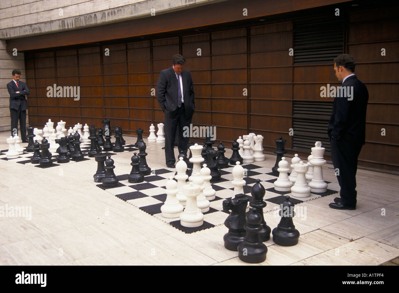 MALE OFFICE WORKERS WEARING SUITS PLAYING GIANT CHESS IN CITY AT ...
