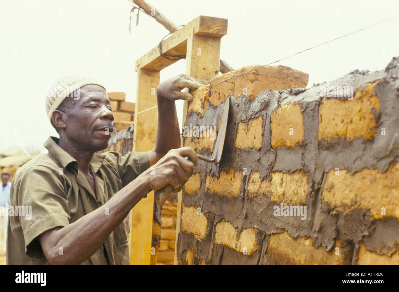 MAN USING TROWEL TO LAY BRICKS AROUND DOORWAY .HOUSE BUILDING IN ...