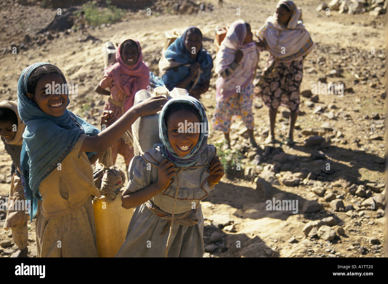 GROUP OF CHILDREN COLLECTING WATER IN PLASTIC CONTAINERS CARRIED ON ...