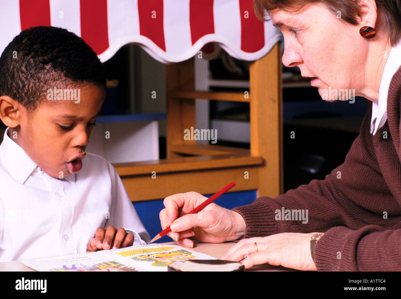 CHILD READING BOOK TO HIS TEACHER PRIMARY SCHOOL BERKSHIRE 1993 Stock ...