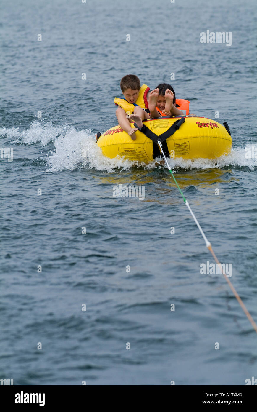 Two children sitting on an inflatable raft in the water Biscarrosse ...