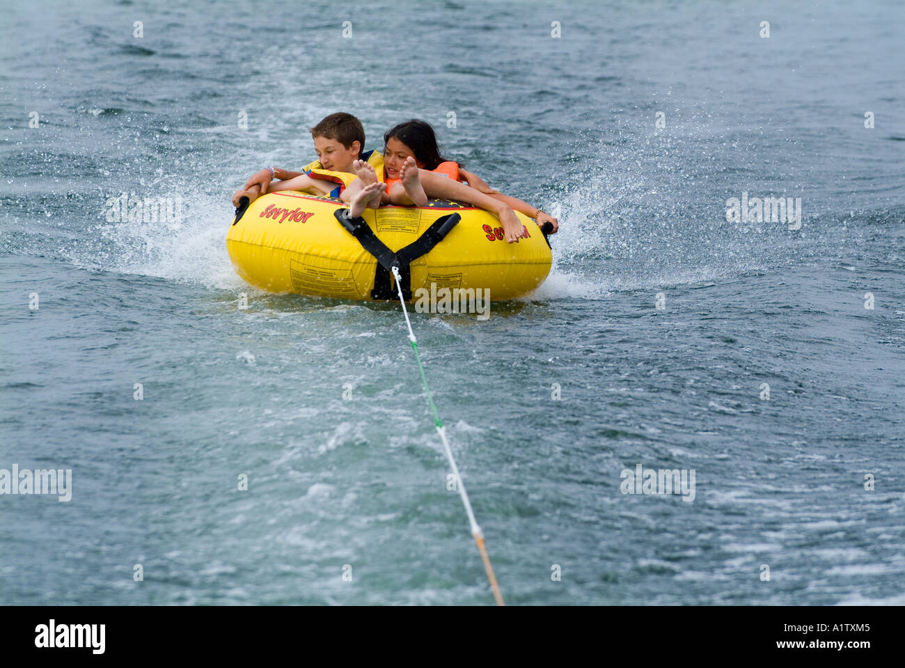 Two children sitting on an inflatable raft in the water Biscarrosse ...