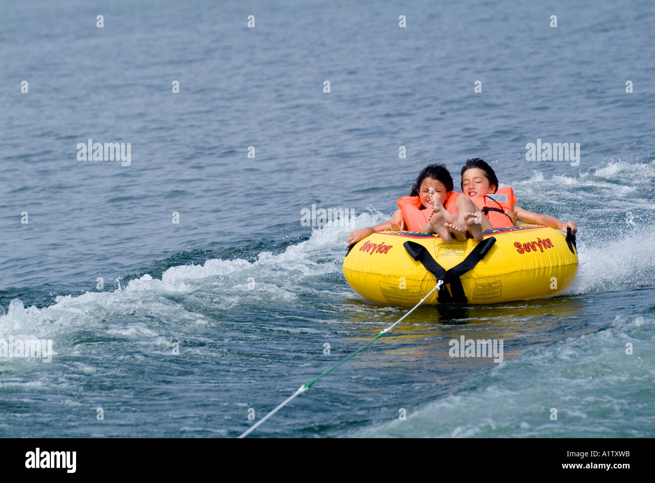 Two children sitting on an inflatable raft in the water Biscarrosse ...