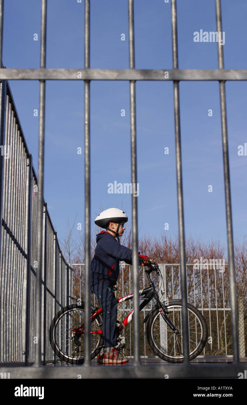 Young boy on a bicycle at BMX bike park behind jump safety rails Stock ...