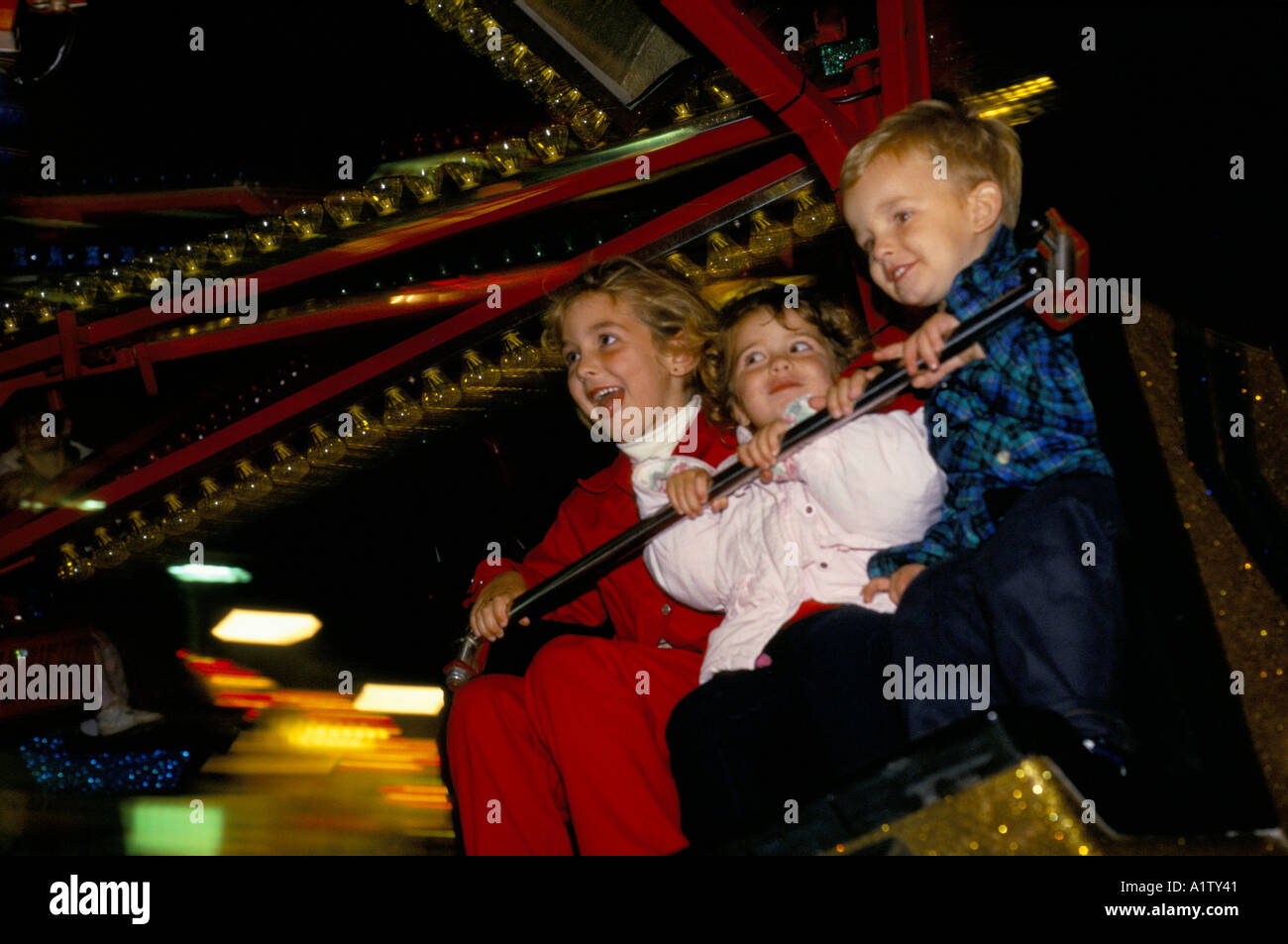 THREE SMALL CHILDREN ON A FUN FAIR RIDE SOUTHAM FAIR Stock Photo - Alamy
