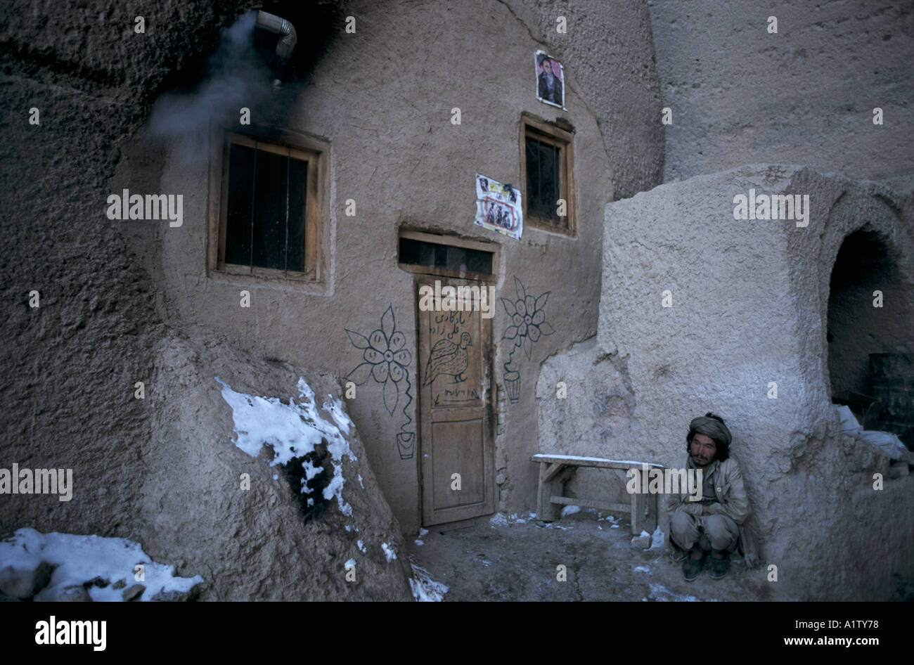 AFGHANISTAN BAMIYAN 1998 .MAN CROUCHING OUTSIDE HIS HOME IN A CAVE ...