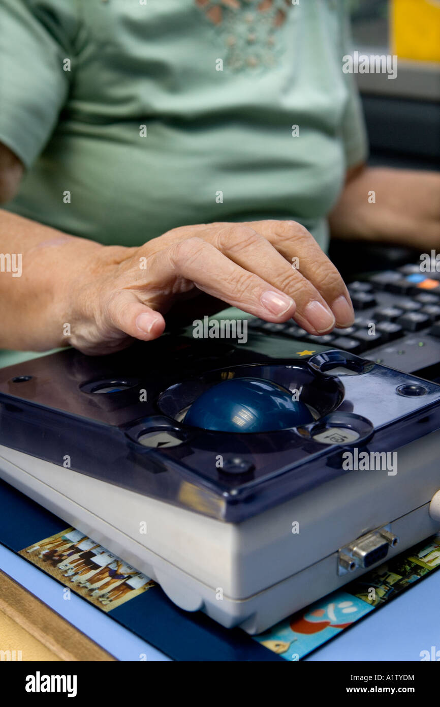 A senior citizen using a specialised roller mouse while learning ...