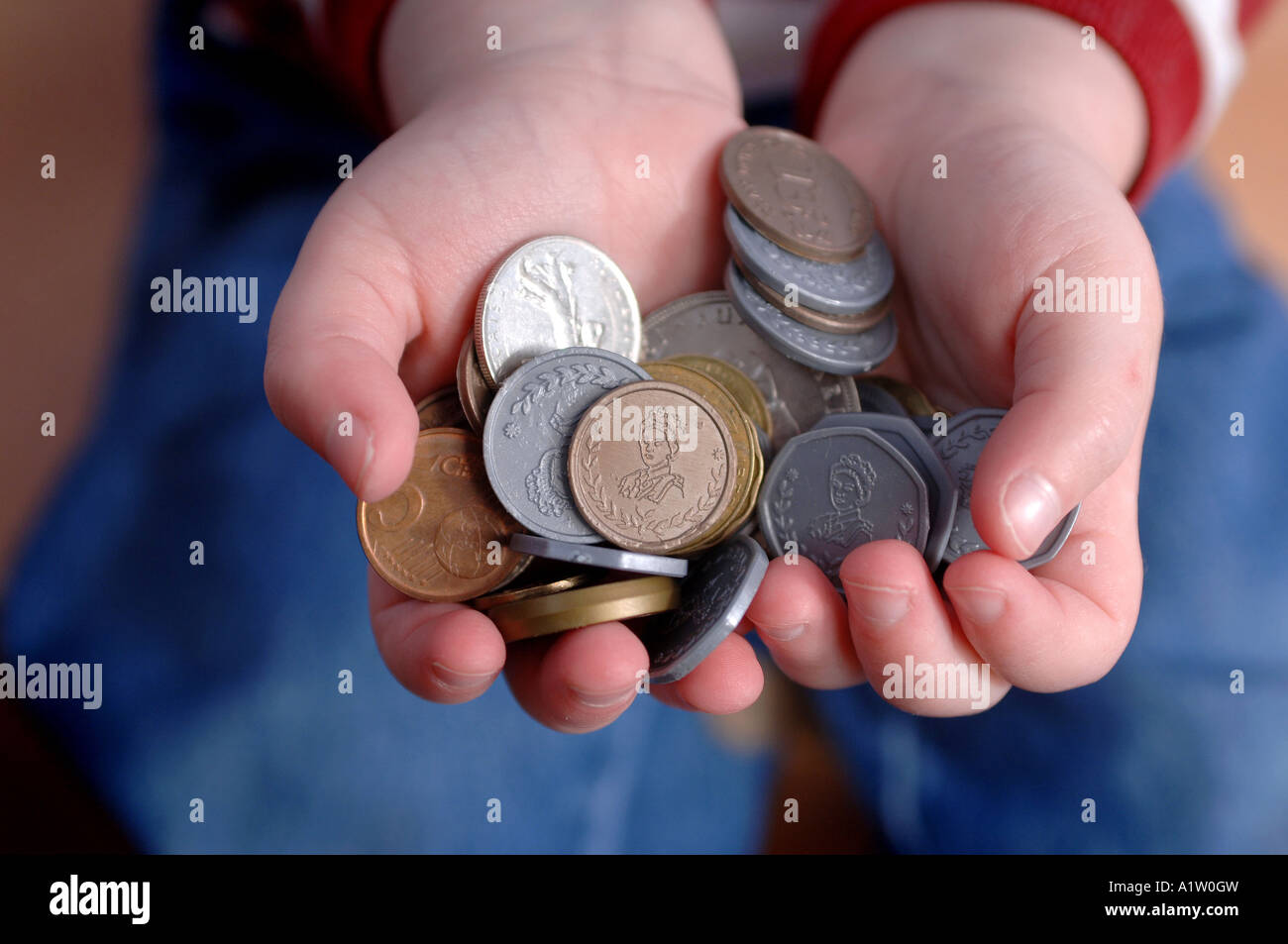 a childs hands holding play plastic money and coins Stock Photo - Alamy