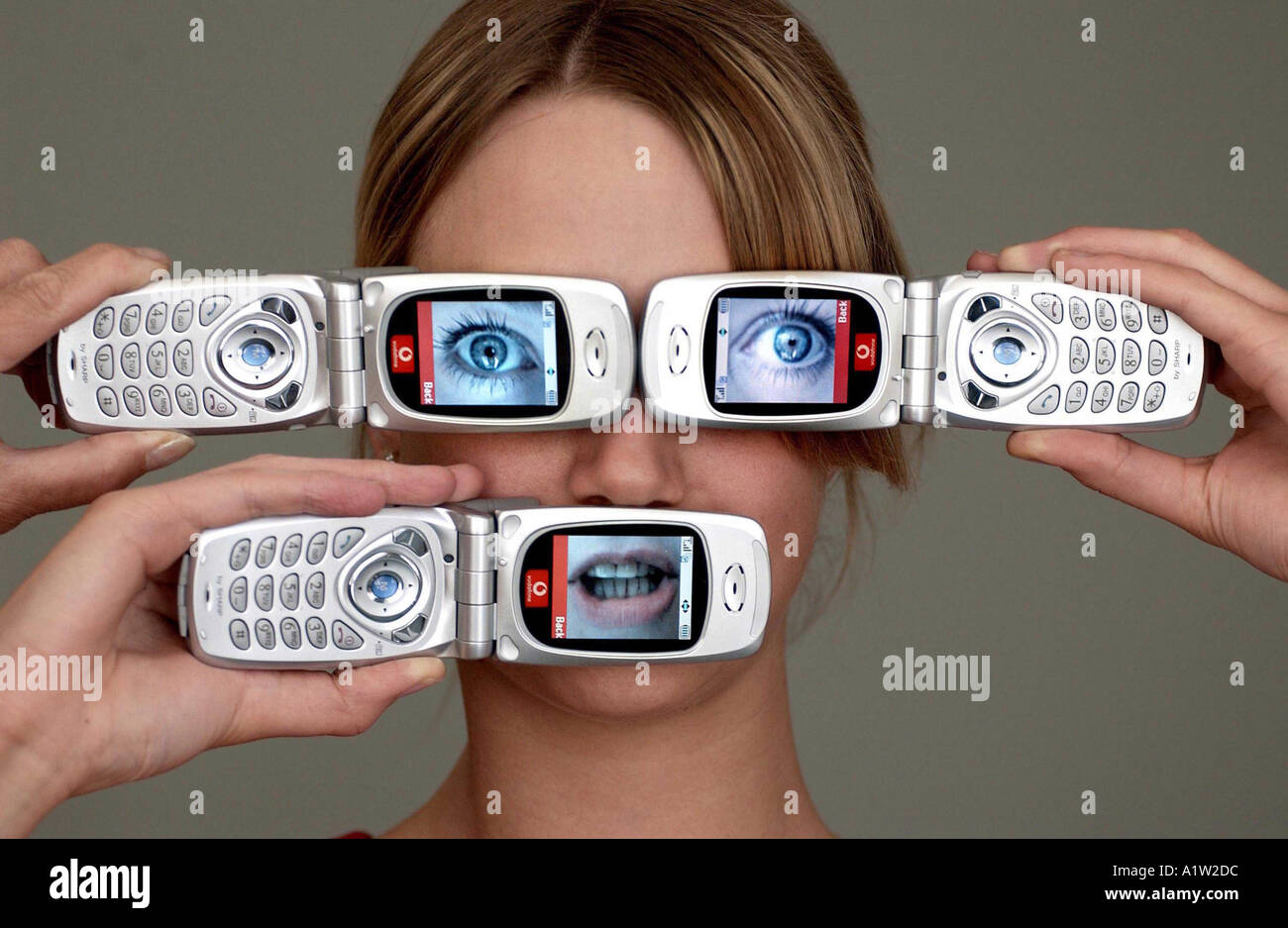 Girl pulling faces with three camera phones Stock Photo - Alamy